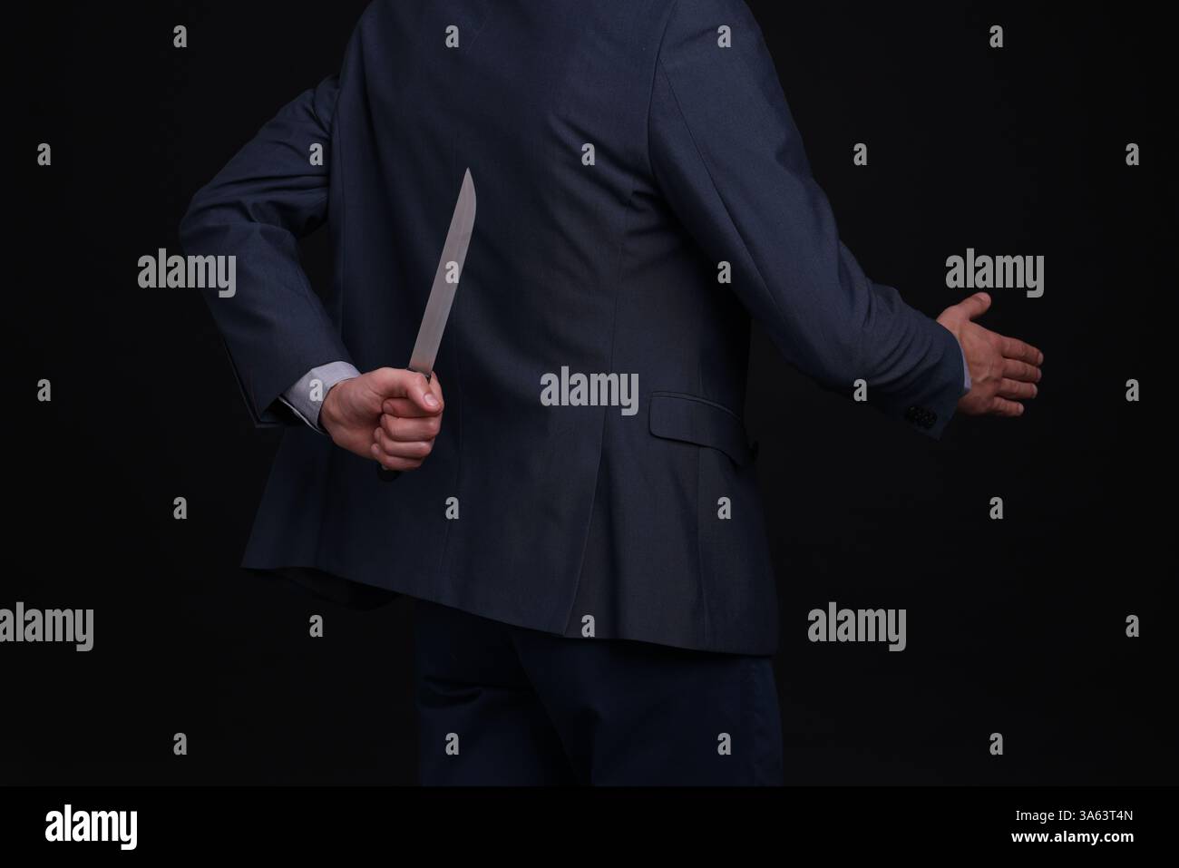 Businessman holding knife behind his back and offering handshake on ...