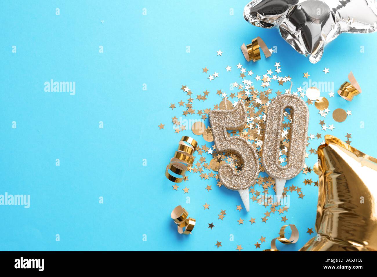 50th birthday. Number shaped candles, balloons and confetti on light ...