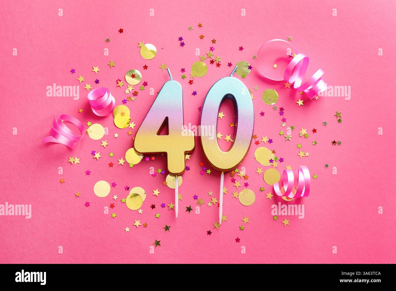 40th birthday. Number shaped candles and confetti on pink background ...