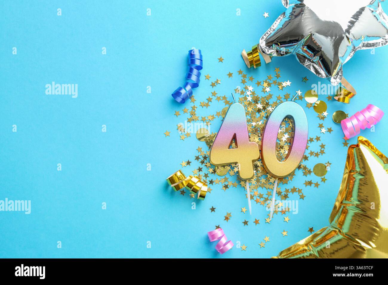 40th birthday. Number shaped candles and party decor on light blue ...
