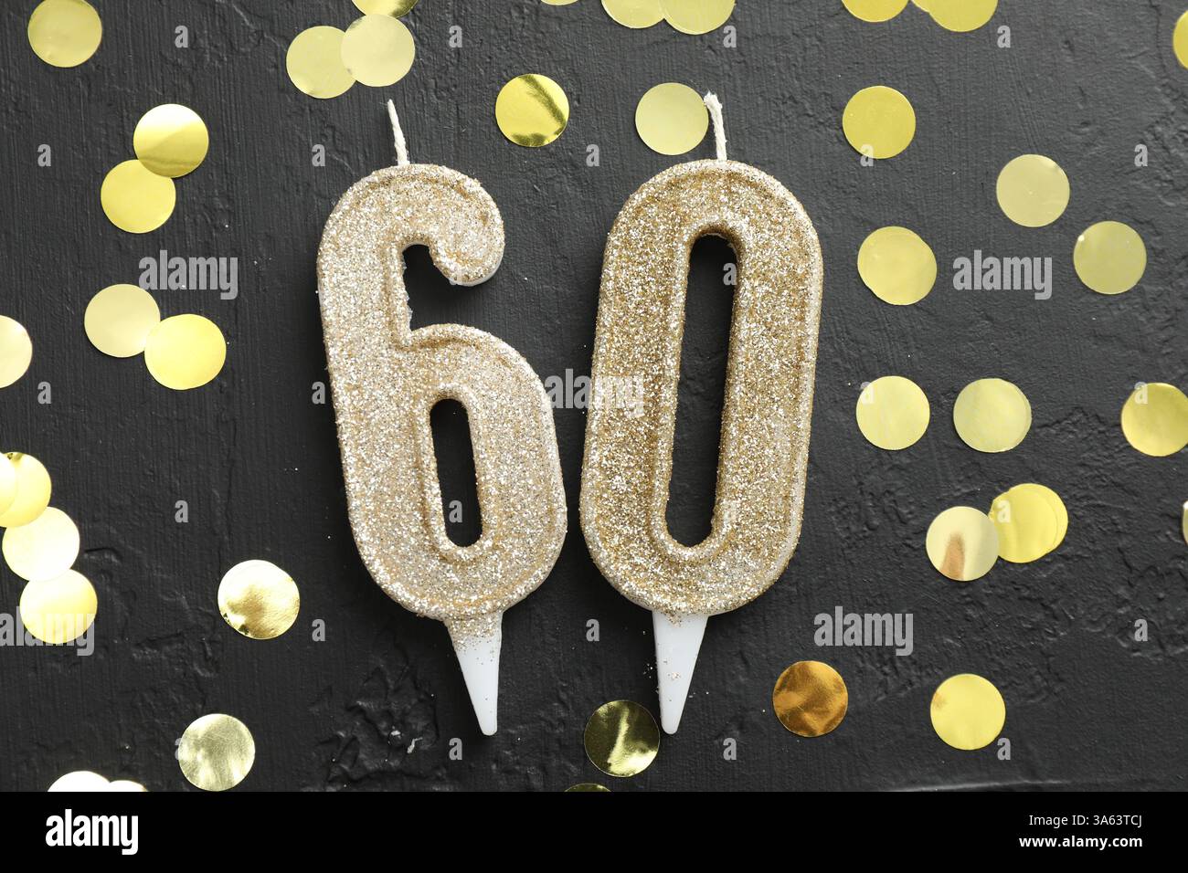 60th birthday. Number shaped candles and confetti on black background ...