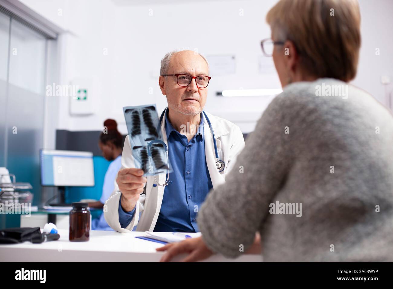 Senior female patient sits across from her retired male physician, who ...