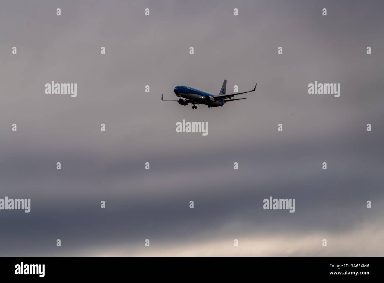 Modern passenger airplane landing gracefully, flying low through an ...