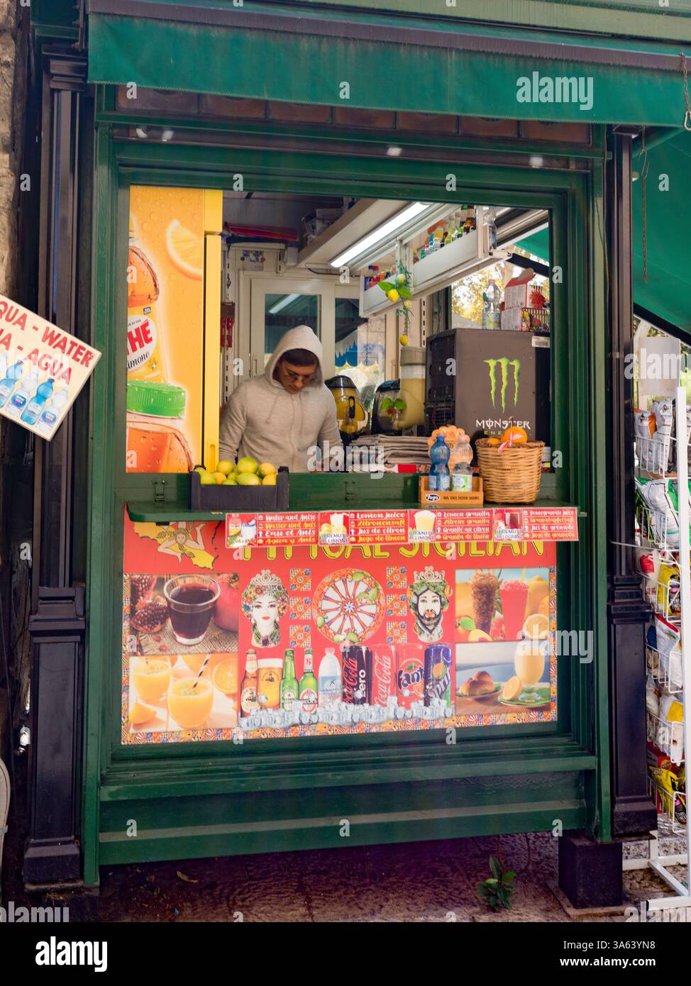 Man standing at the counter of a refreshment stand on the street in ...
