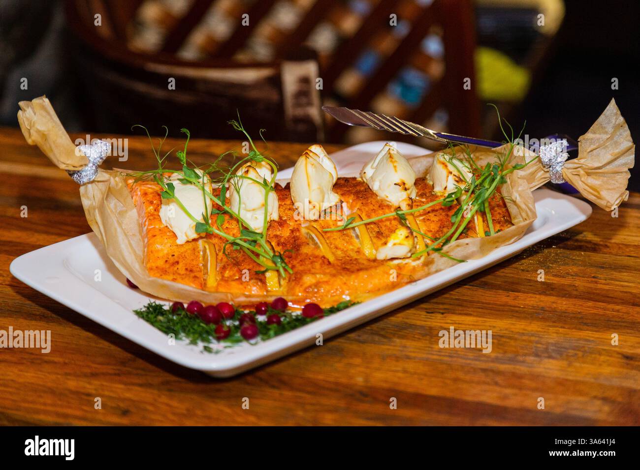 Baked fresh red fish on papyrus in a plate with cheese and lemon Stock ...