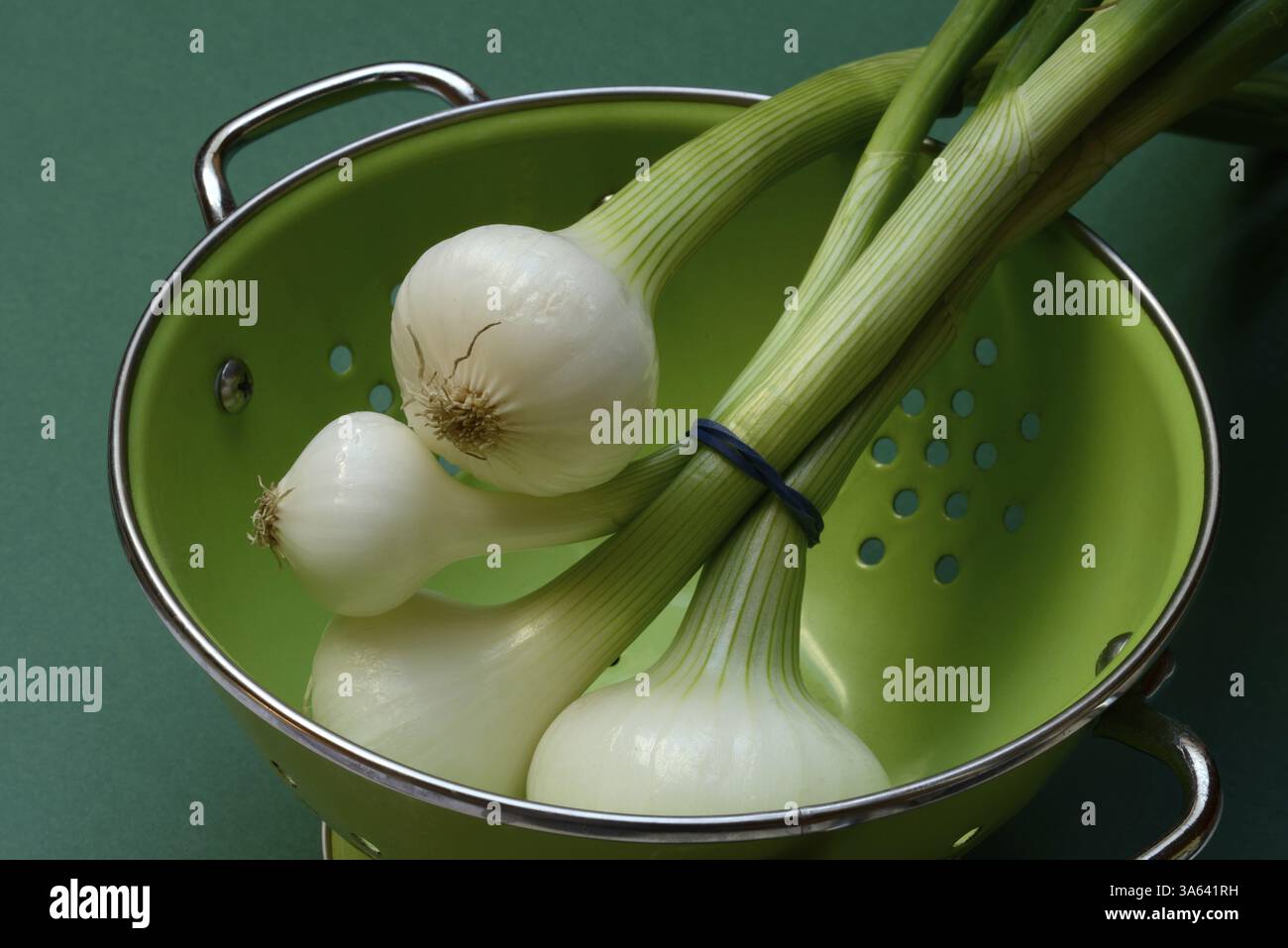 Onion, spring onions in sieve pot Stock Photo - Alamy