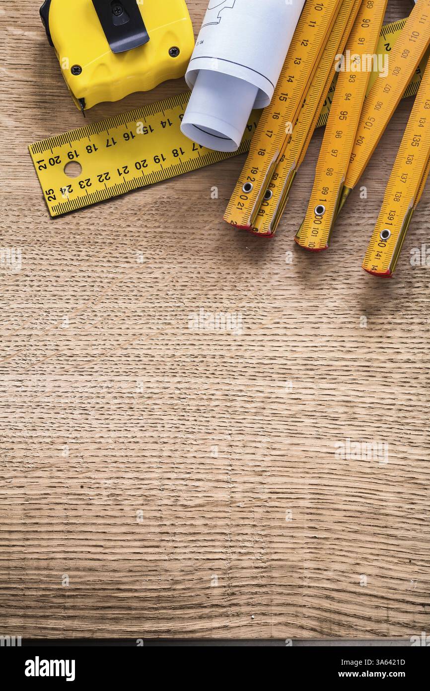 Construction plans and yellow instruments of measurement on oaken ...