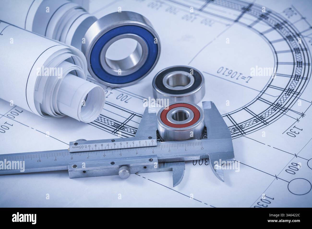 Rolls of construction plans rolling bearings and slide caliper on ...