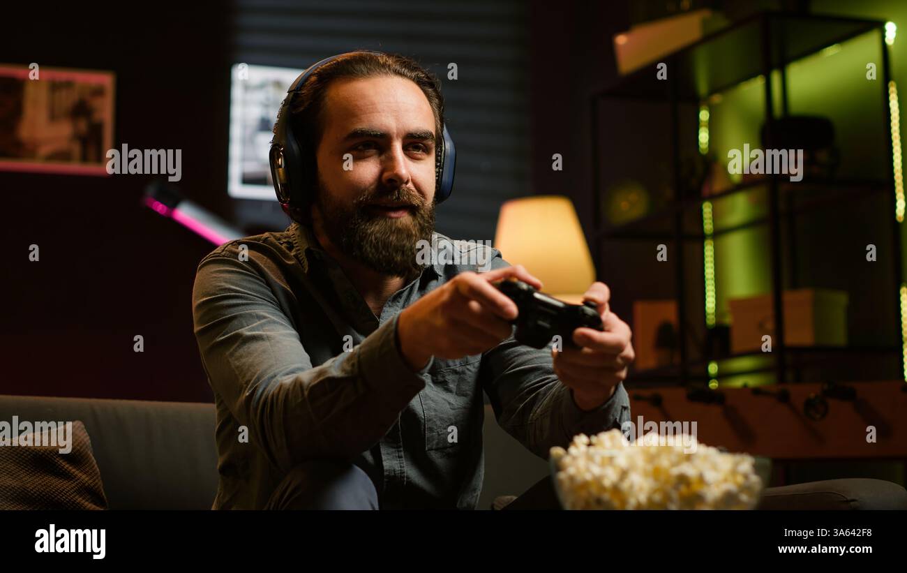 Excited man playing videogames using controller, having fun in neon ...
