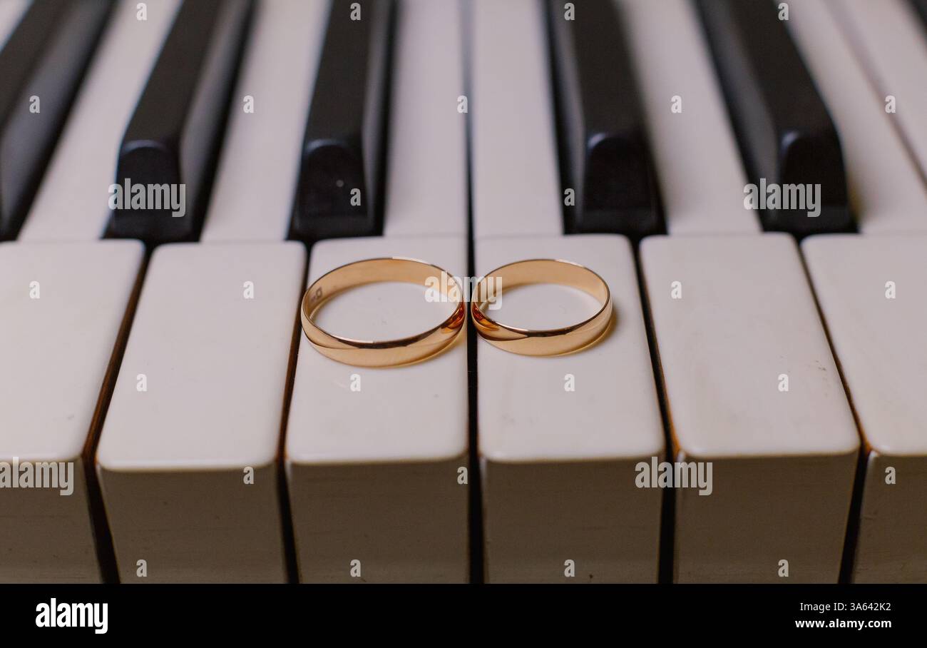 Wedding rings on the piano keys golden wedding rings lie on the piano ...