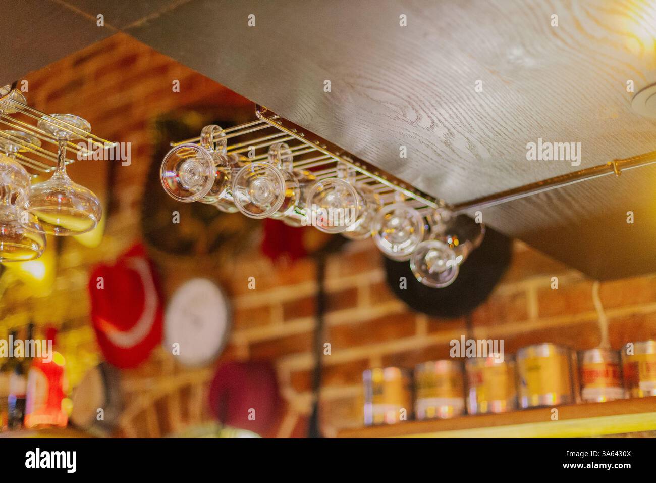 Glasses hang over the bar in the restaurant. Latte cups Stock Photo - Alamy