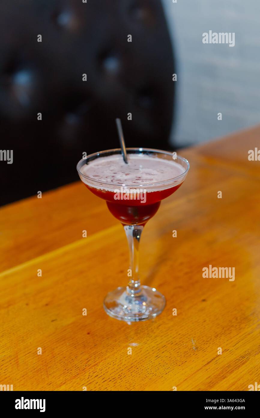 Red cocktail with white foam cocktail glasses with a tube alcoholic ...