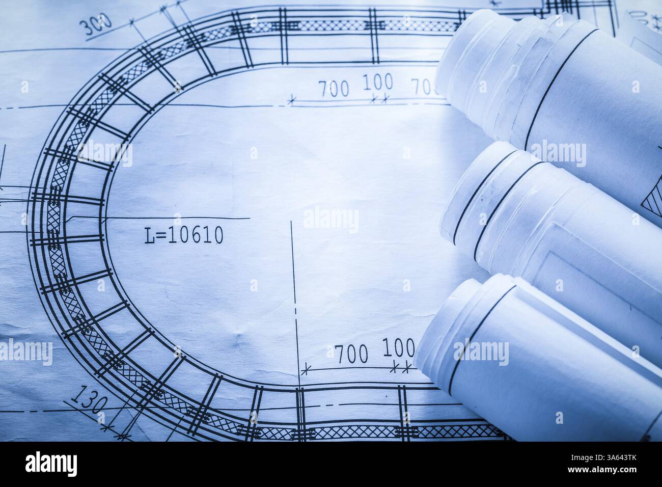 Rolled up construction plans on blueprint top view Stock Photo - Alamy