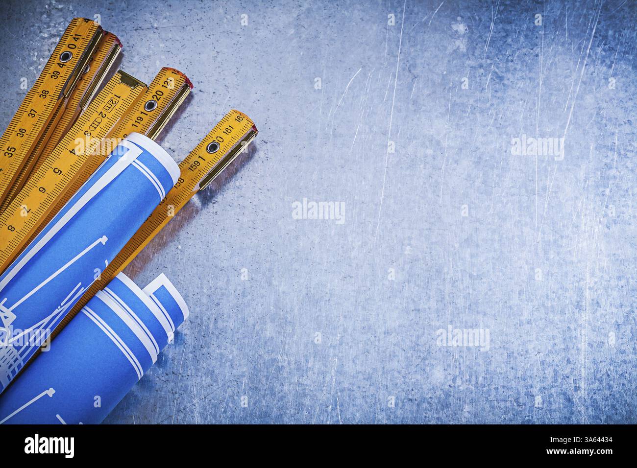 Collection of blue construction drawings wooden meter on metallic ...