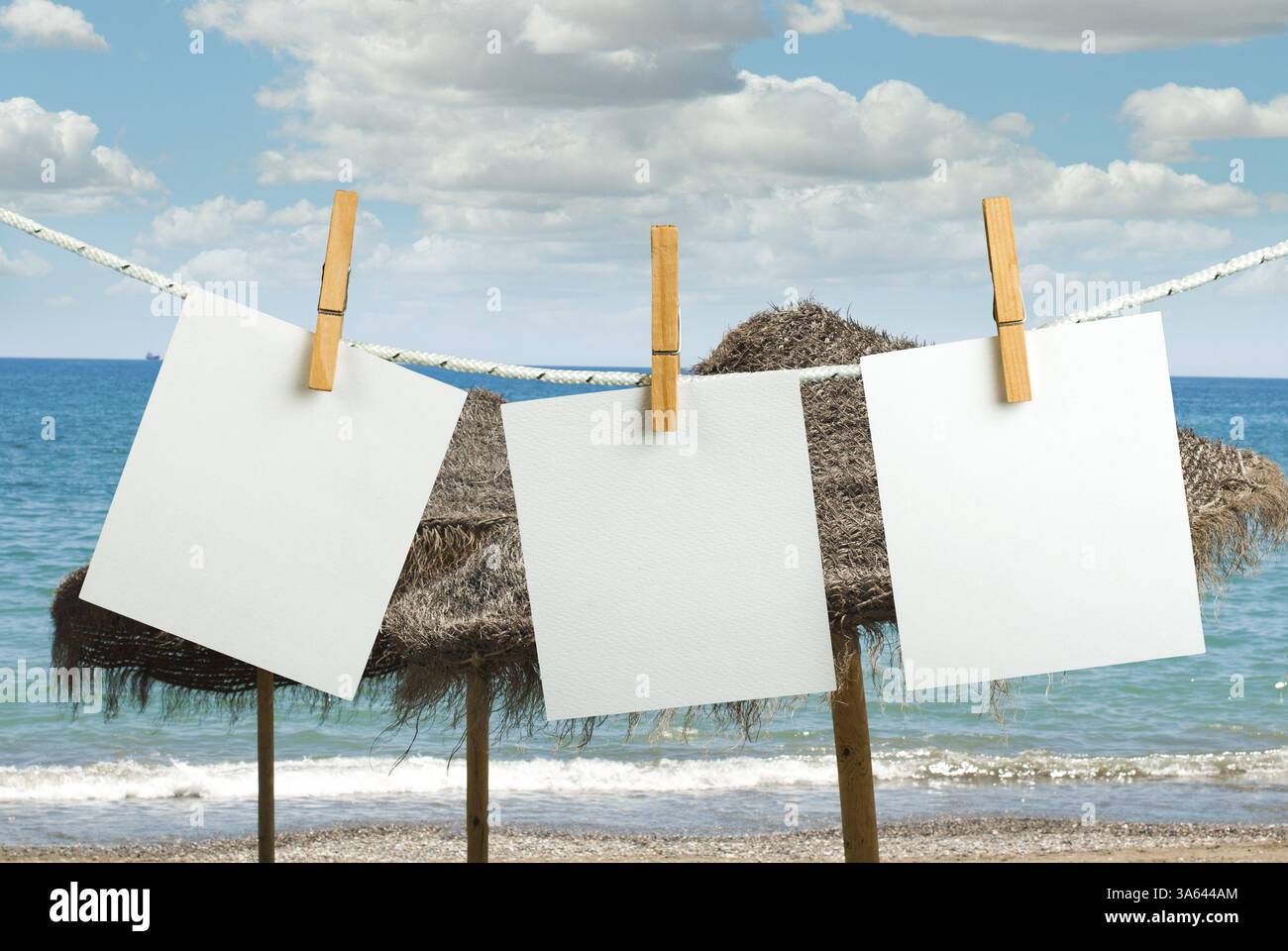 Note papers hooked on a rope. Beach background Stock Photo - Alamy