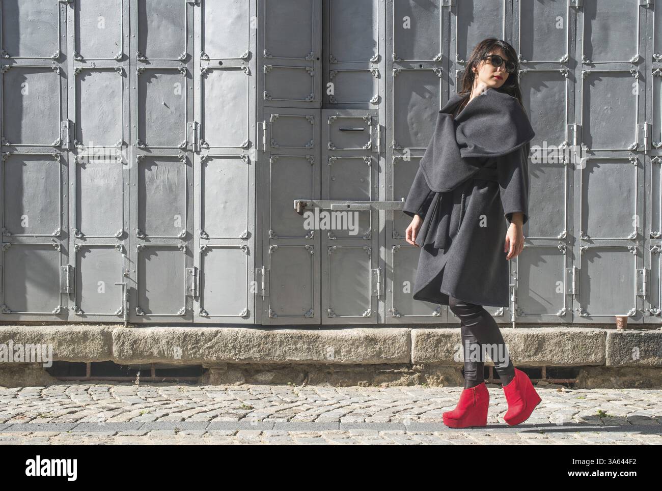 Woman walking on a street. Grey background. Bulgaria Stock Photo - Alamy