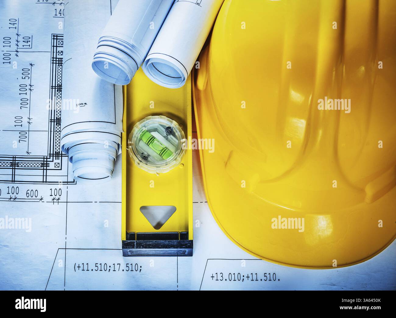 Hard hat construction level drawings on blueprint Stock Photo - Alamy