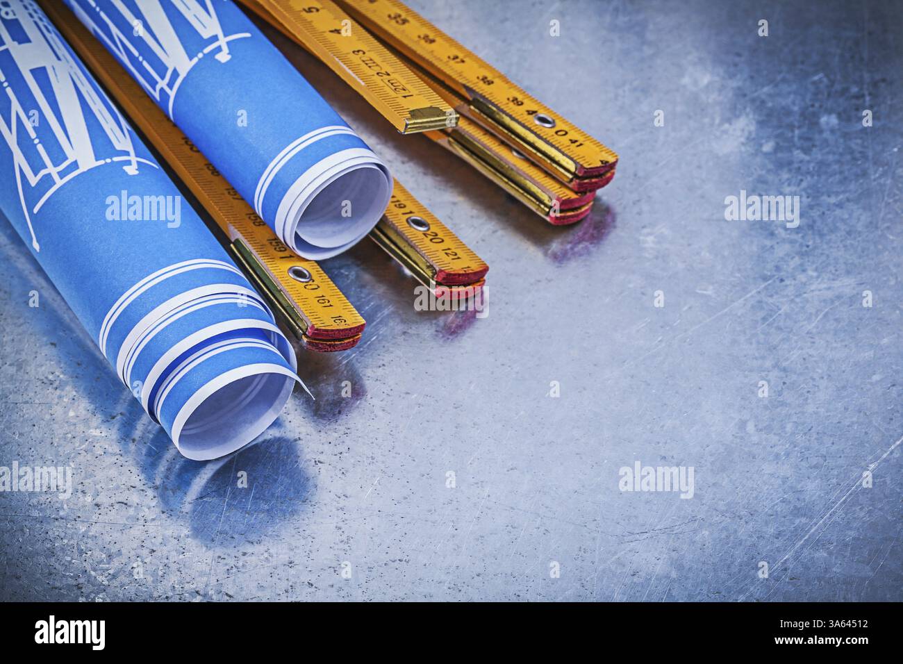 Composition of blue construction drawings wooden meter on metallic ...
