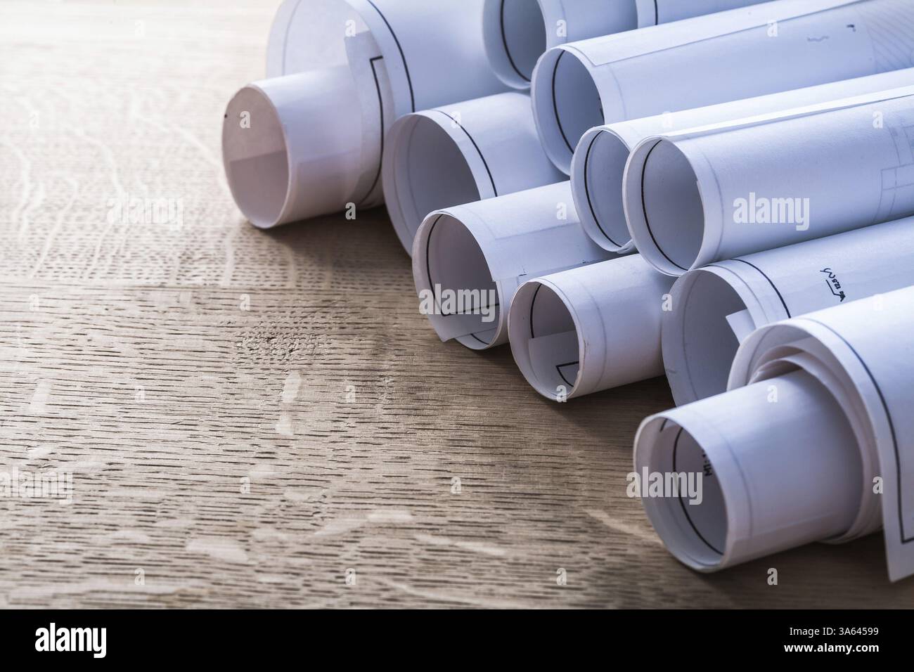 Collection of blueprint rolls on wooden oaken board construction ...
