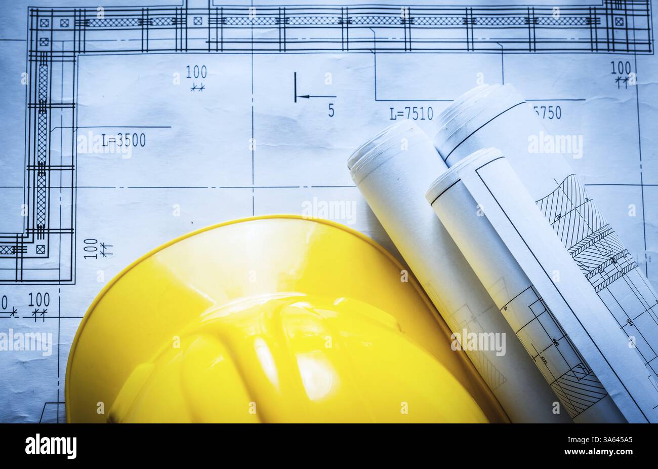 Hard hat construction drawings on blueprint Stock Photo - Alamy