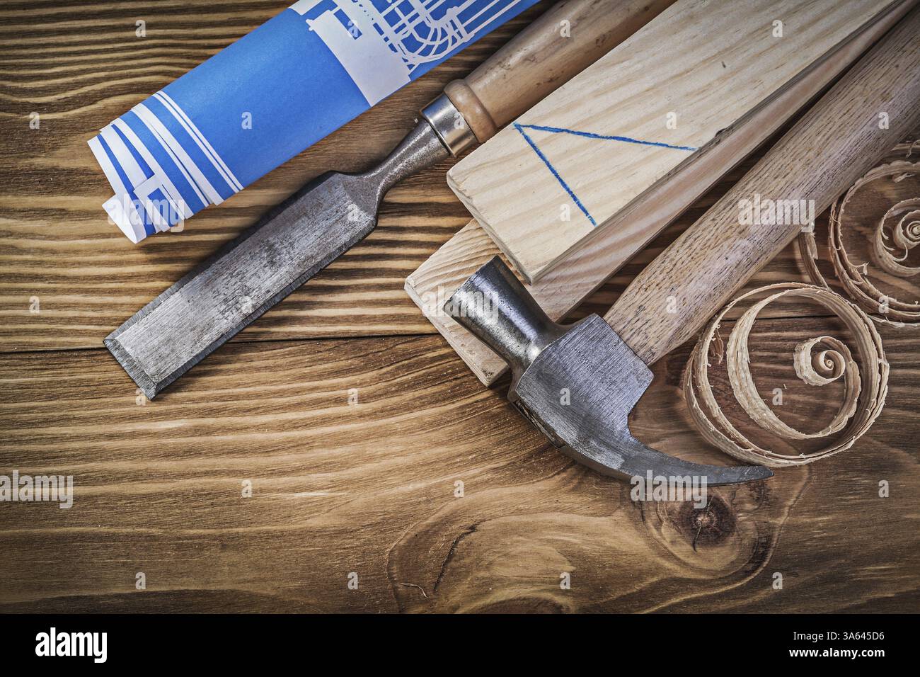 Blue blueprint claw hammer flat chisel wooden studs shavings on wood ...
