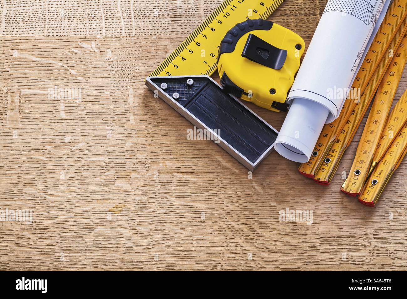 Blueprints square ruler tape measure and wooden meter on oak board ...