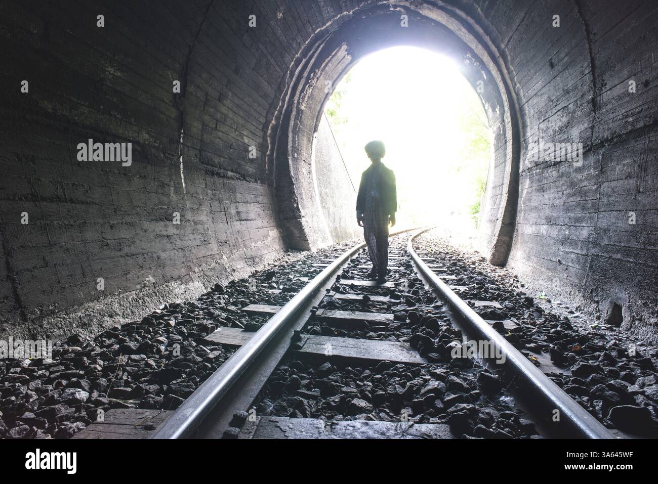 Child walking in railway tunnel. Vintage clothes Stock Photo - Alamy