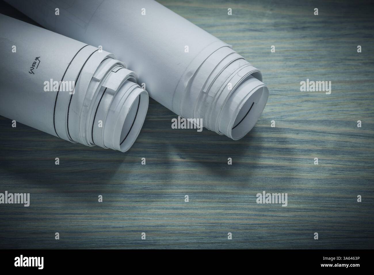 Close up view rolled blueprints on board Stock Photo - Alamy