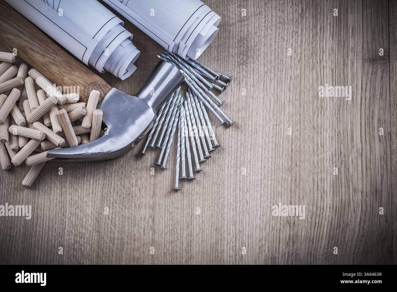 Construction plans claw hammer stack of dowels and nails Stock Photo ...