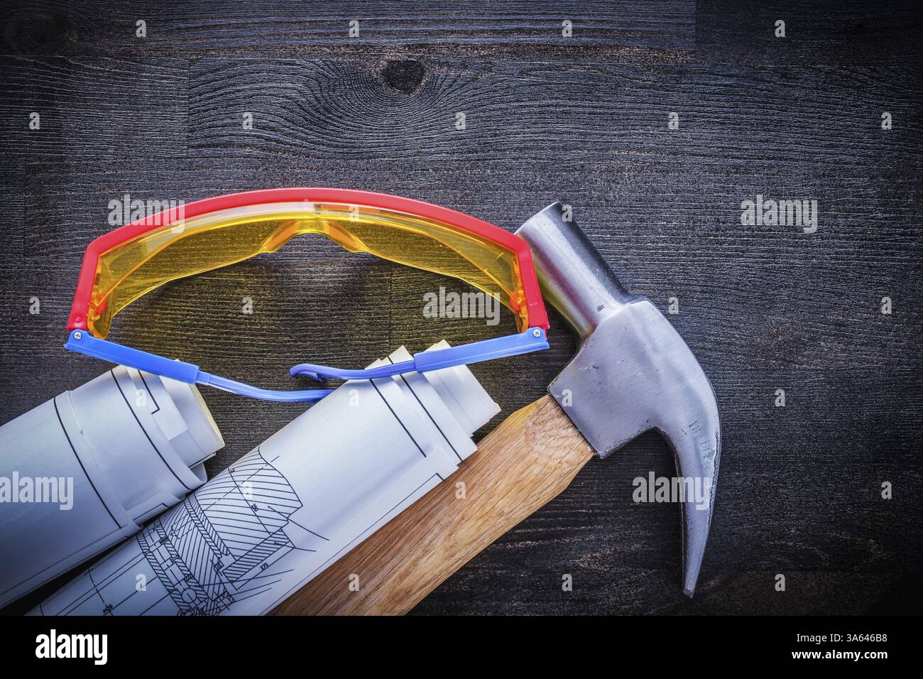 Rolled blueprints hammer goggles on wood board Stock Photo - Alamy