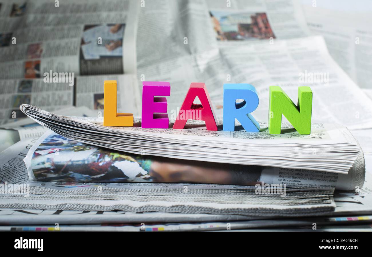 Word learn on newspaper. Wooden letters Stock Photo - Alamy