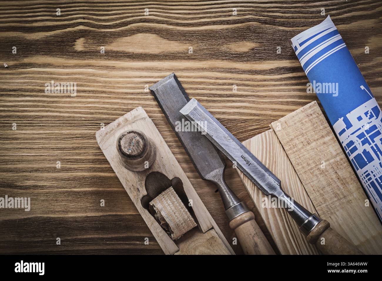 Blue rolled up engineering drawing planer chisels wooden studs on wood ...