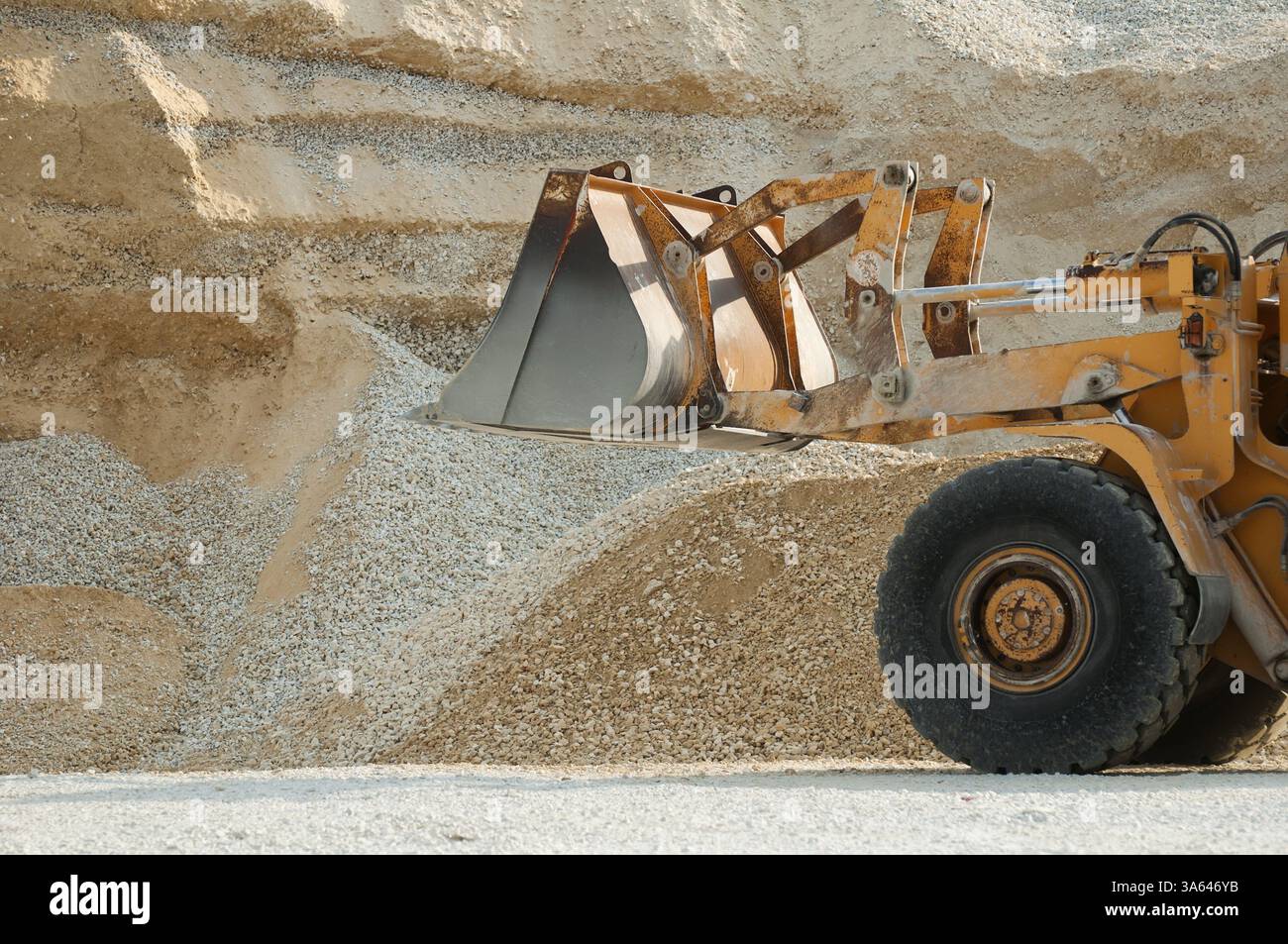 Bulldozer in quarry. Huge pile of limestone and sand Stock Photo - Alamy