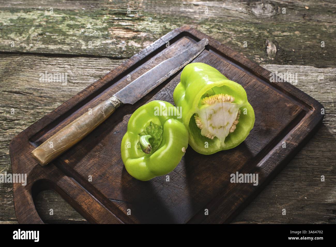 Cut green pepper on wood. Backlight Stock Photo - Alamy