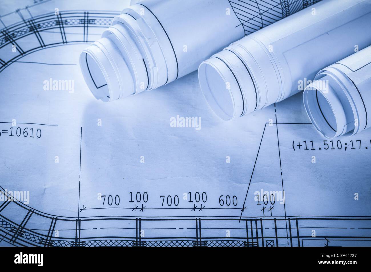 Rolled up engineering drawings on blueprint top view Stock Photo - Alamy