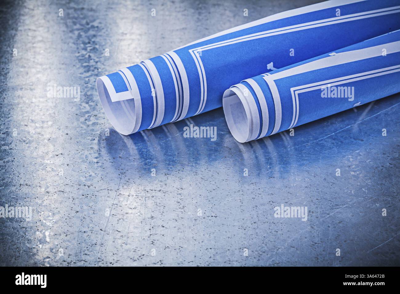 Rolls of blue blueprints on metallic background construction concept ...