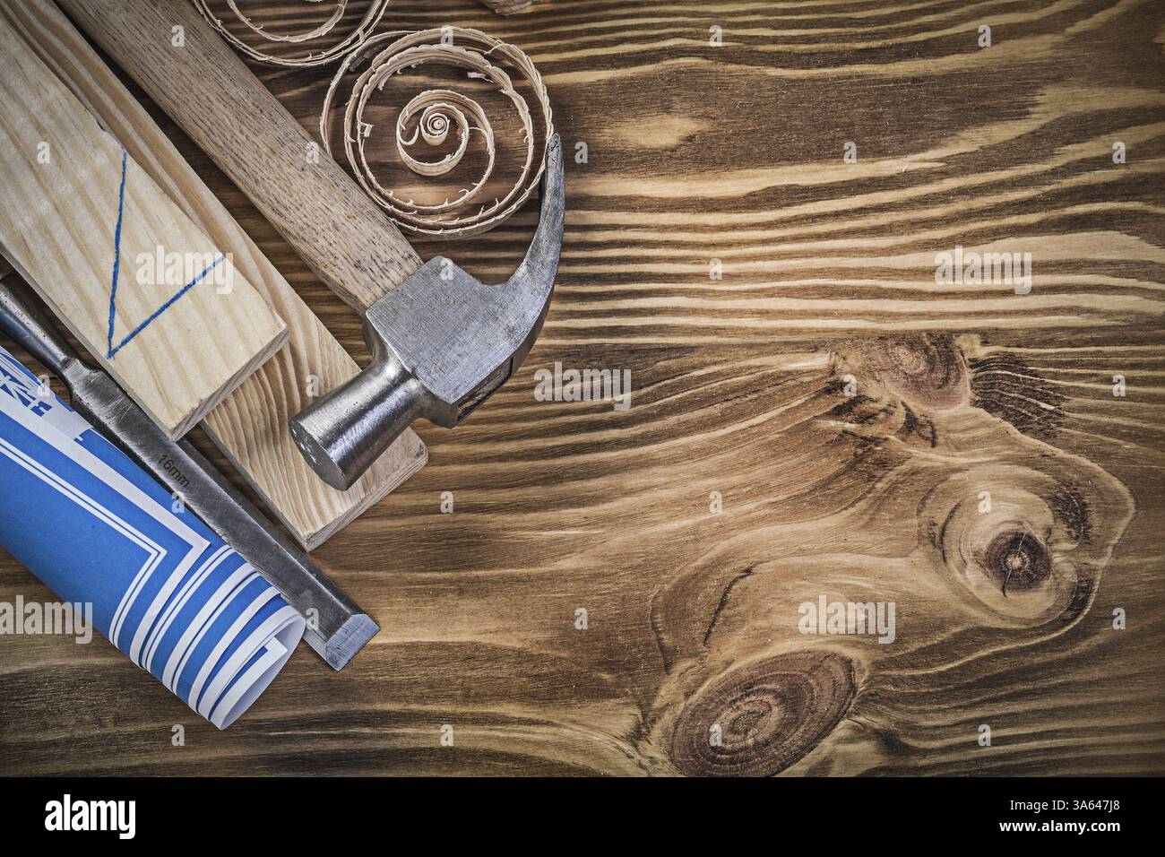 Blue construction plan claw hammer flat chisel wooden studs shavings on ...