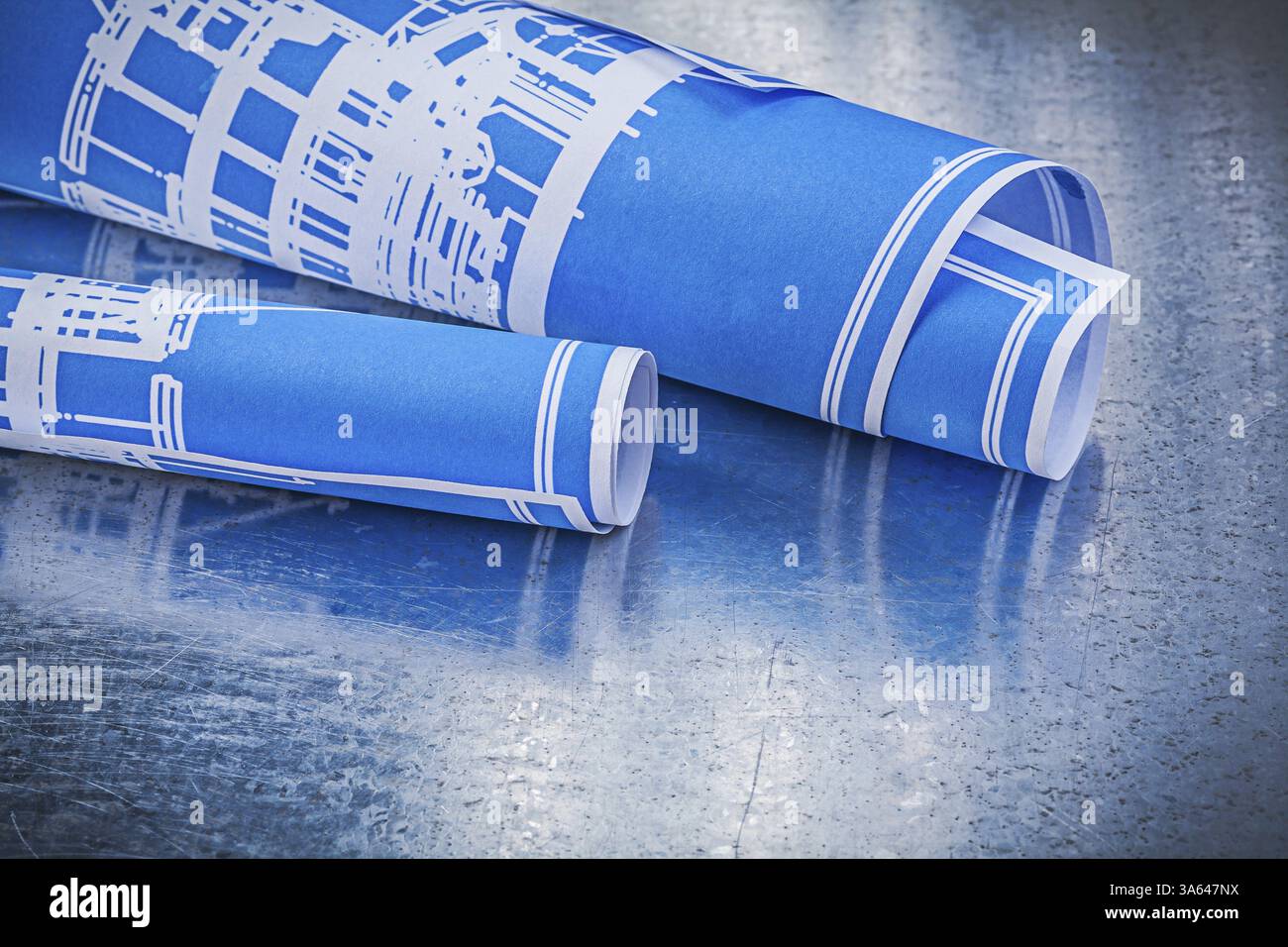 Blue rolled engineering drawings on metallic background construction ...