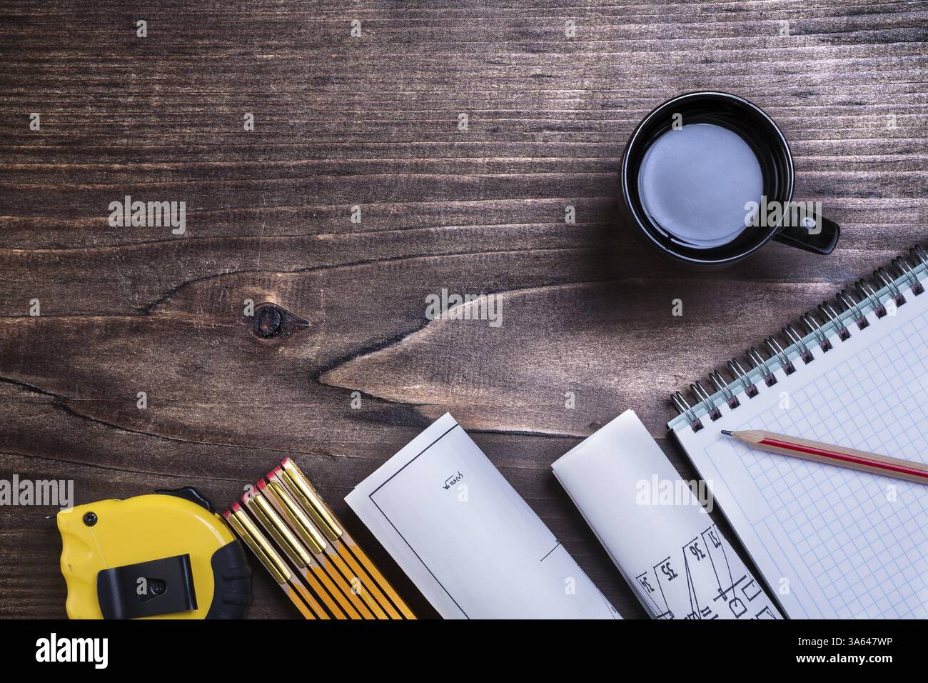 Checked copybook pencil blueprints tape line wooden meter and cup of ...