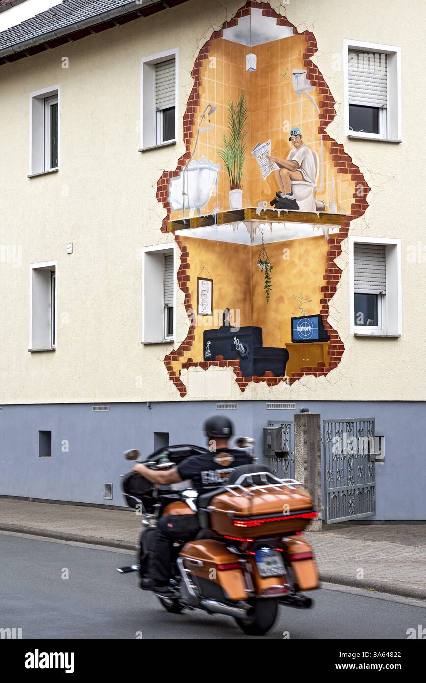 House with funny wall painting, view into interiors, man reads ...