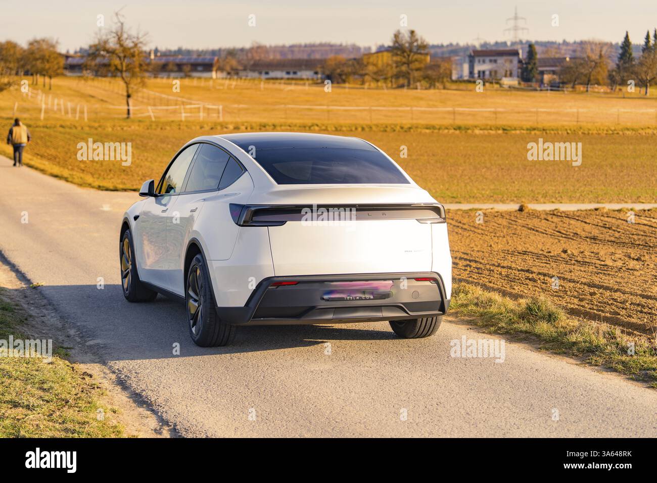 Rear view of a white car on a country road in sunny autumn weather ...