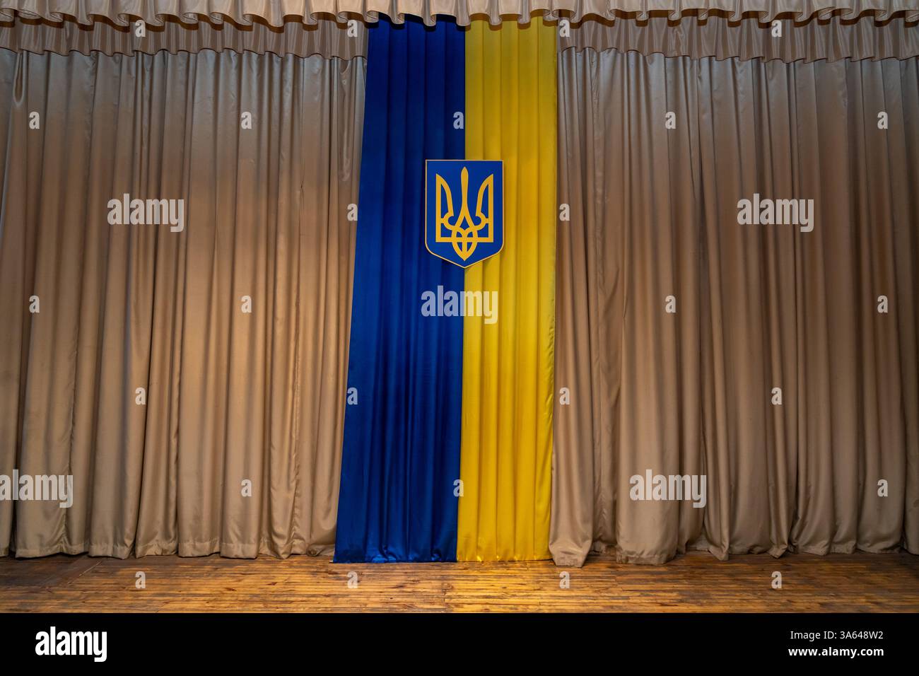 The backdrop features blue and yellow curtains arranged vertically ...