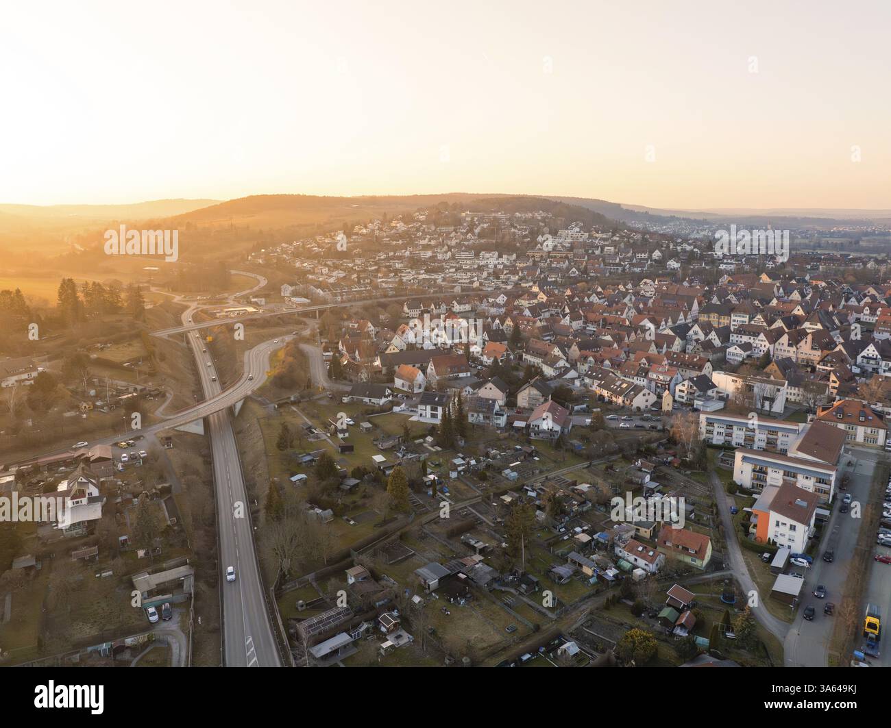 Aerial view of a cityscape at sunset with streets and residential areas ...