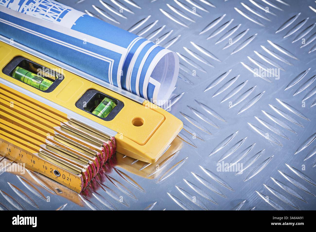 Construction level wooden meter blue rolled blueprints on fluted metal ...