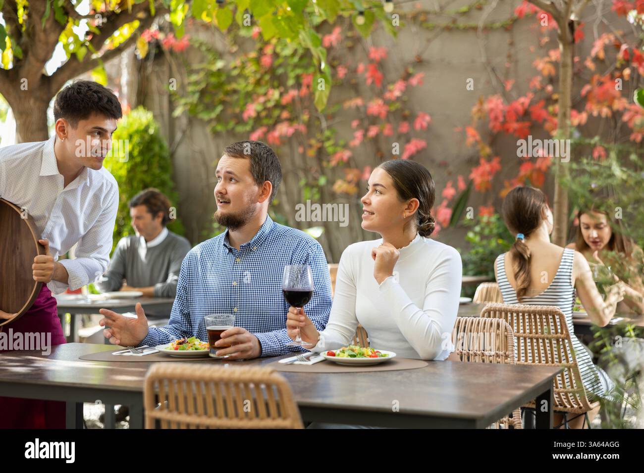 Waiter takes an order from a couple in love who decided to meet in an ...