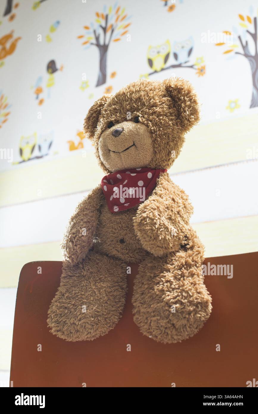 Teddy bear in a baby room on chair Stock Photo - Alamy