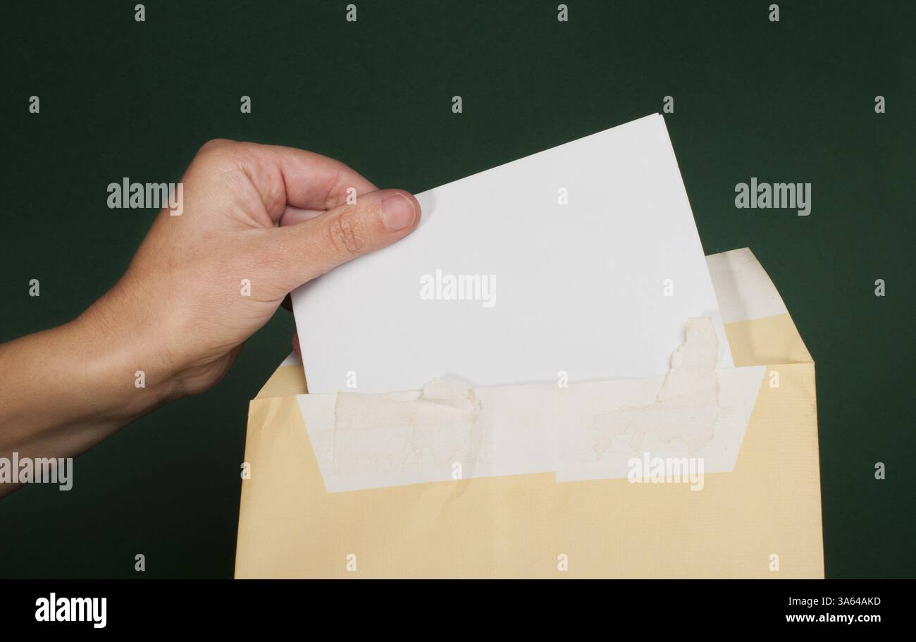 Hand that open a letter from brown envelope. Dark green background ...