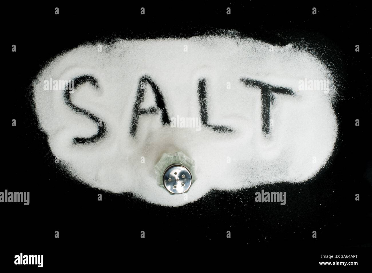 Word Salt on black background written by spilled salt Stock Photo - Alamy