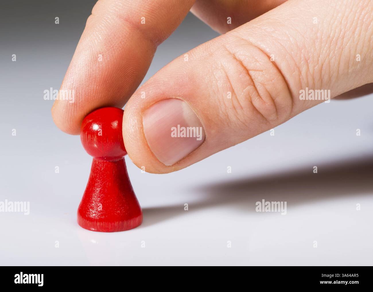 Hand holding red pawn on white background. Close up Stock Photo - Alamy