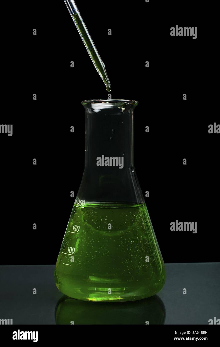 Laboratory beaker filled with green color liquid substances and ...
